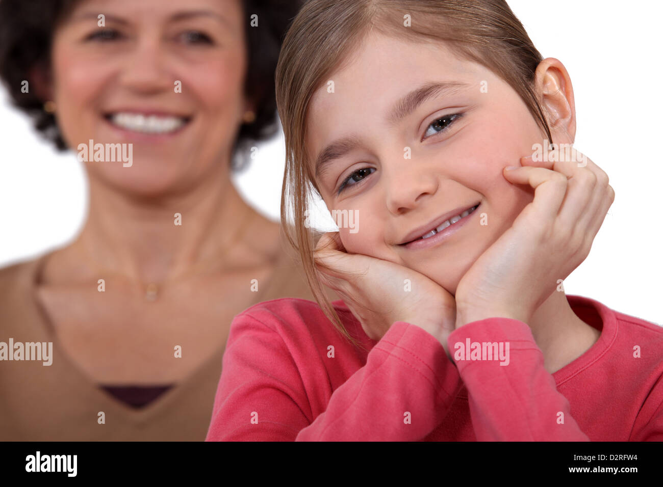 little girl posing with mother all smiles in background Stock Photo - Alamy