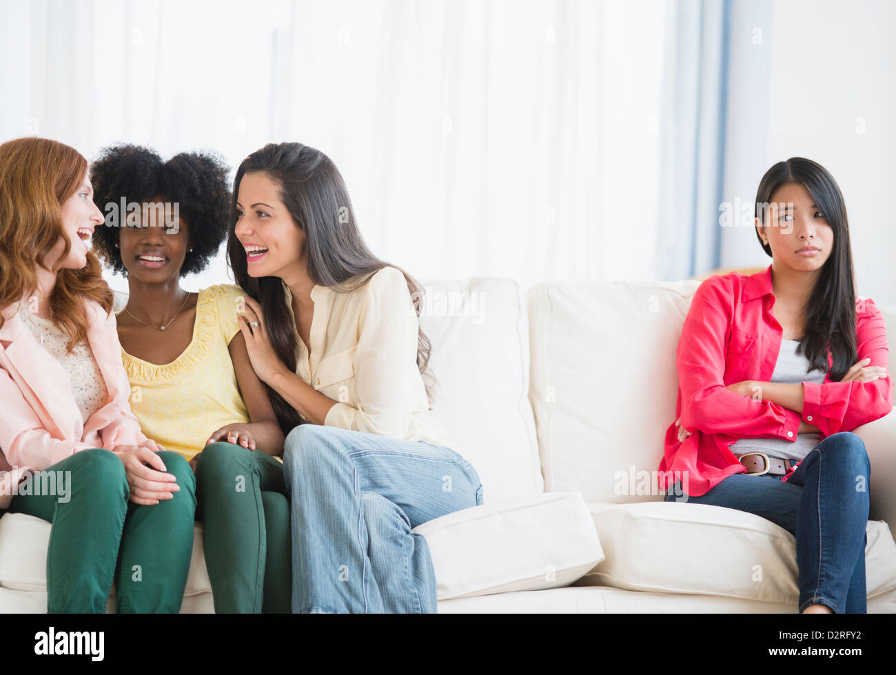 Woman excluded from conversation on sofa Stock Photo - Alamy