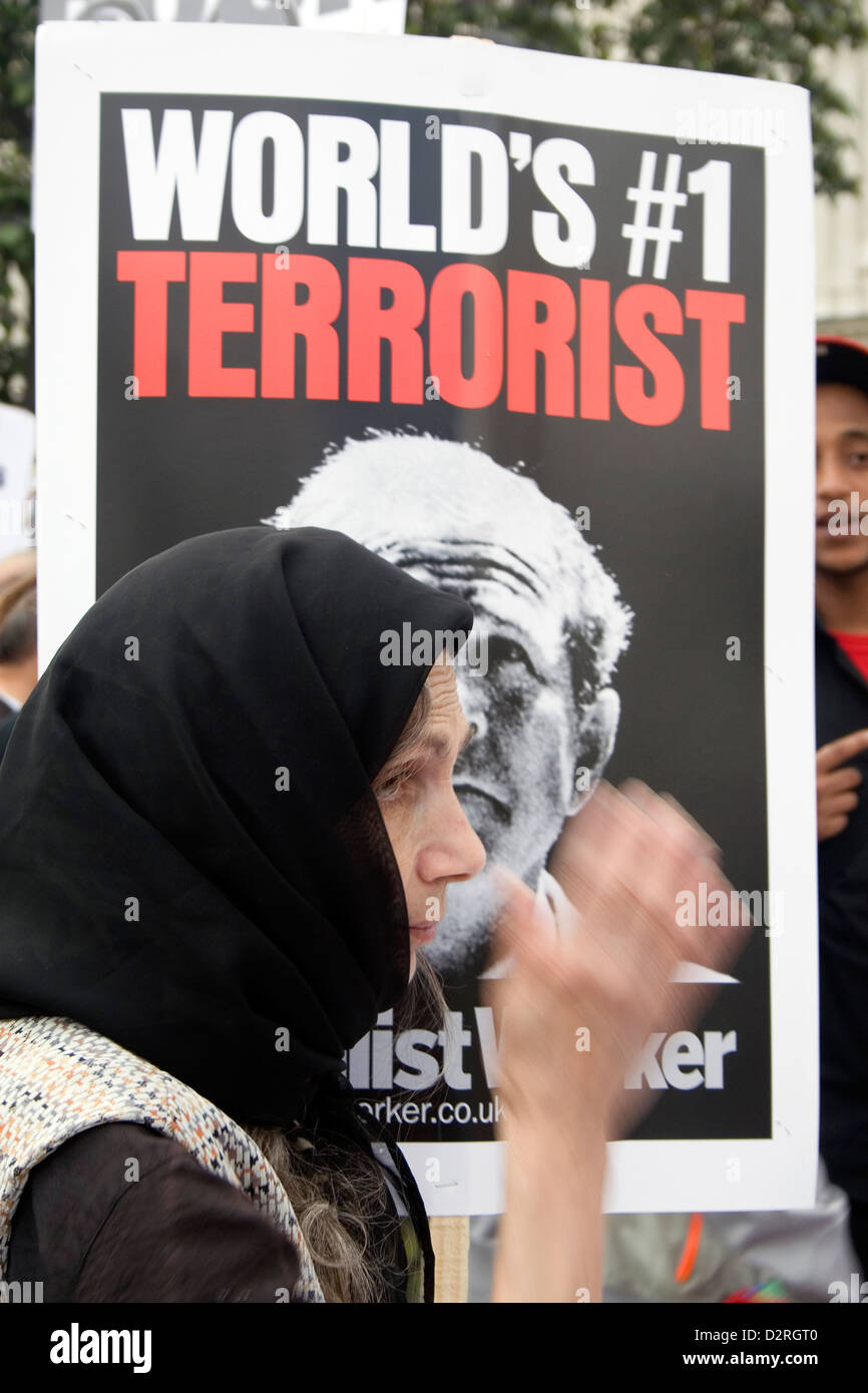 A Muslim woman walks in front of an anti George Bush poster Stock Photo ...