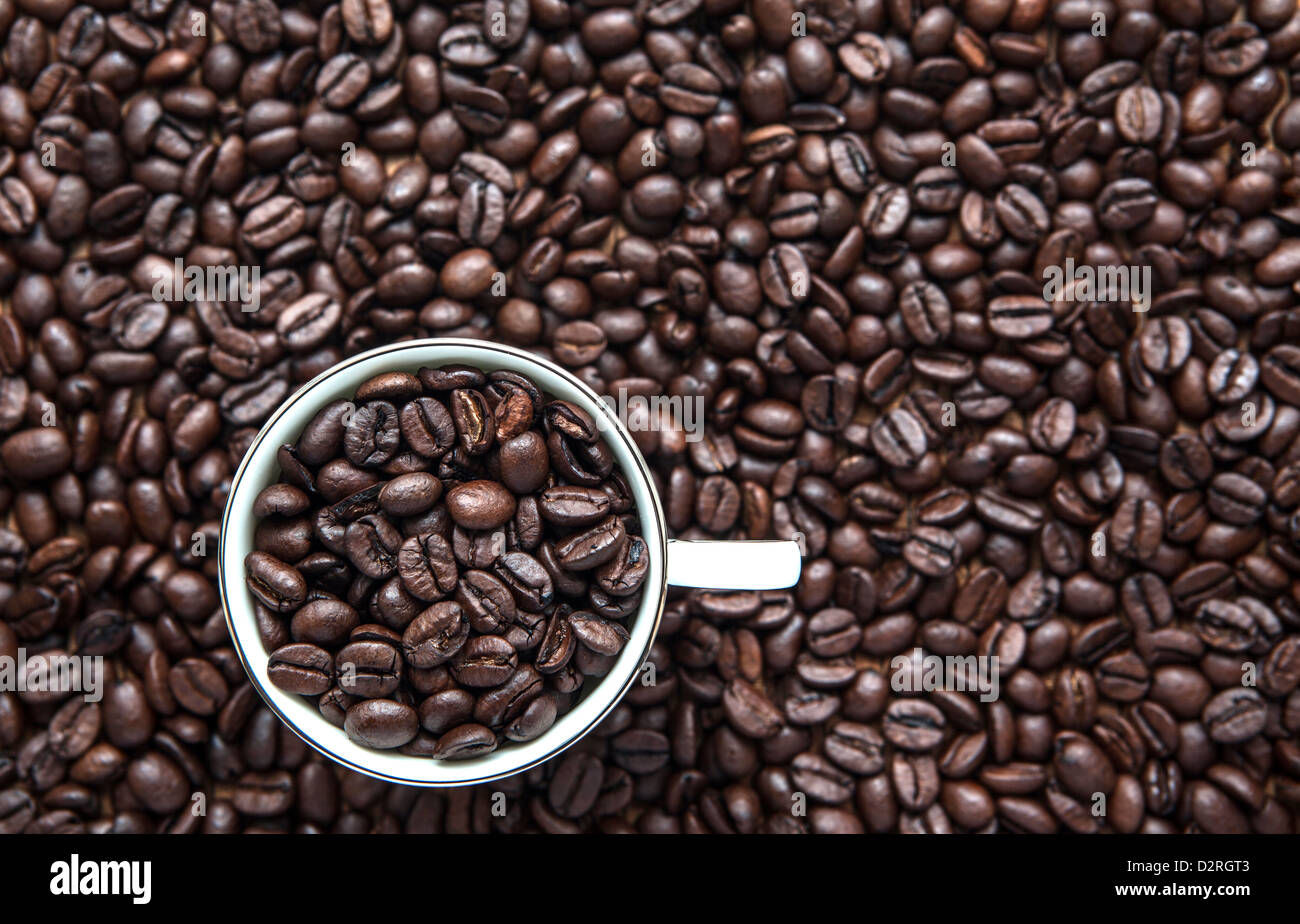 A cup of coffee beans with beans background Stock Photo - Alamy