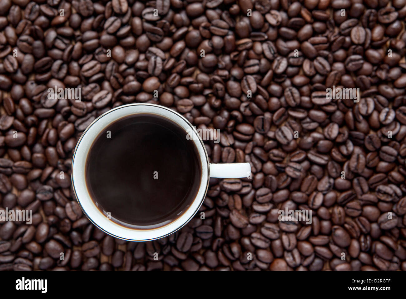A cup of coffee with beans background Stock Photo - Alamy