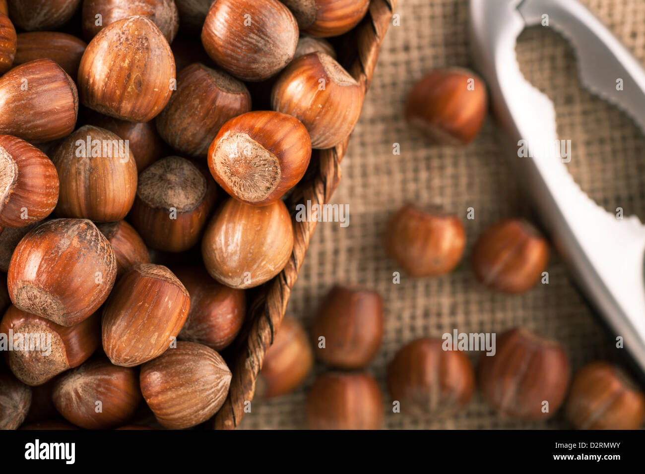 Whole hazelnuts in basket with nutcracker on table, from directly above ...
