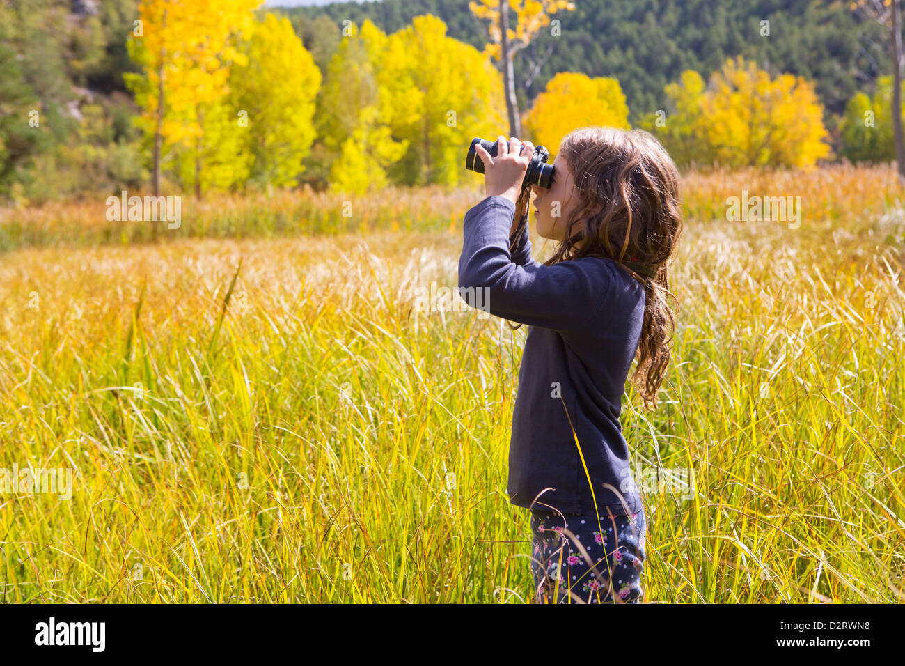 Explorer binocuar looking kid girl in yellow autumn nature outdoor ...