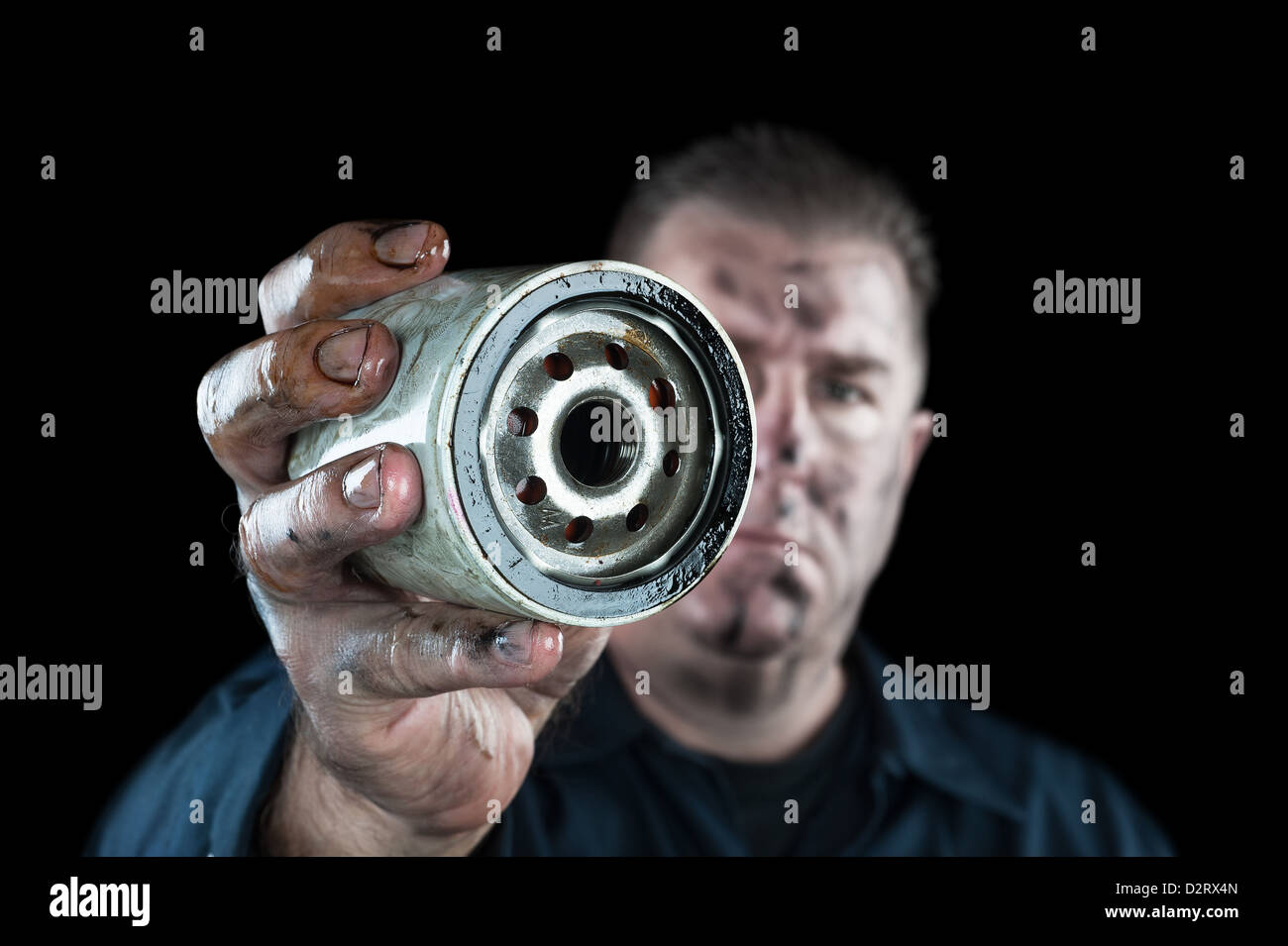 An auto mechanic showing a dirty oil filter during general car ...