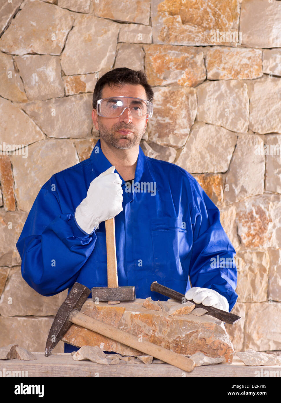 Masonry mason stonecutter man with hammer working on stone wall ...