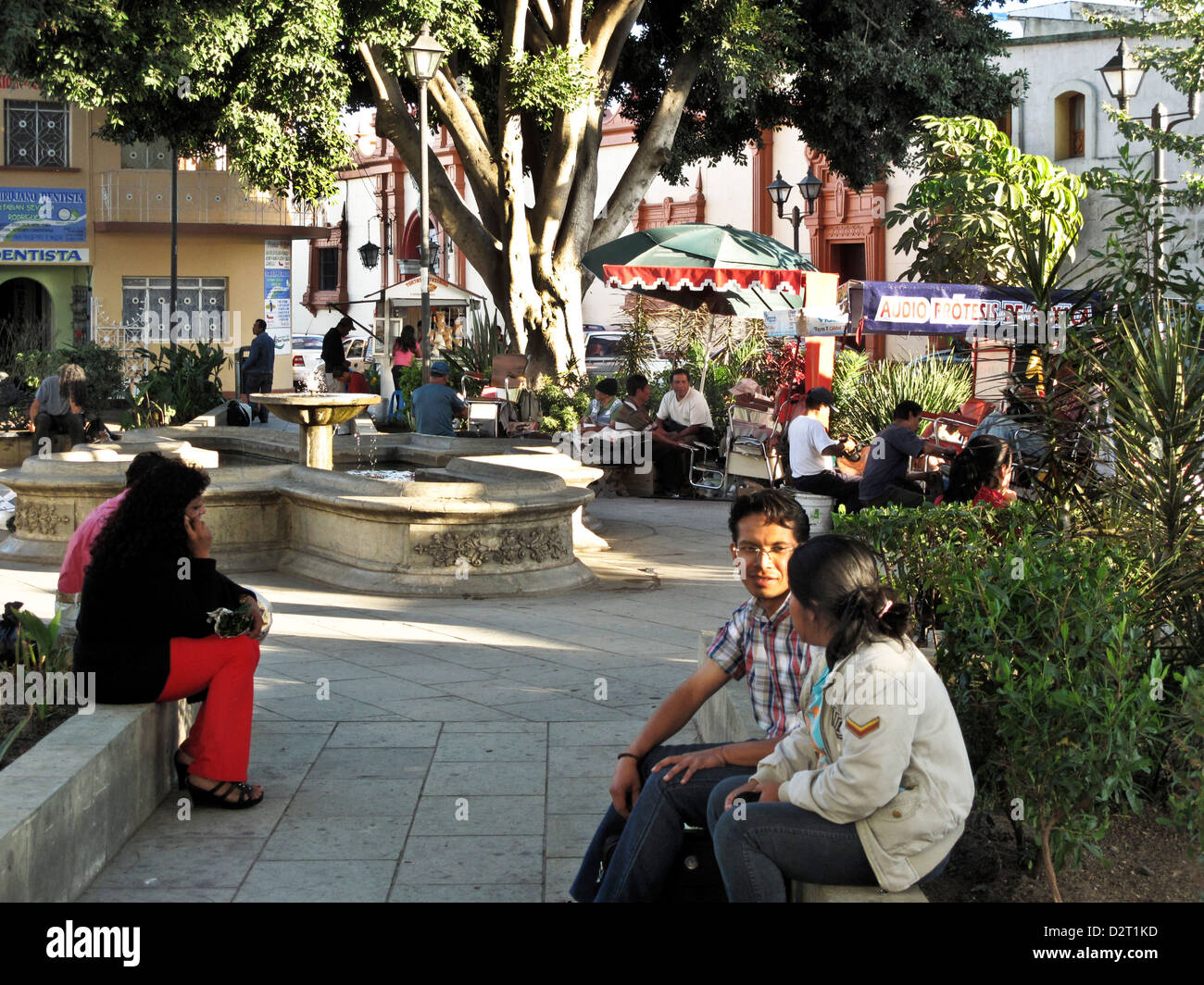 diverse Mexican people enjoying social activities on sunlit afternoon ...