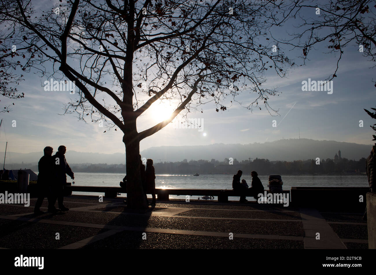Sunset along the lake of Zurich with people in silhouette Stock Photo ...