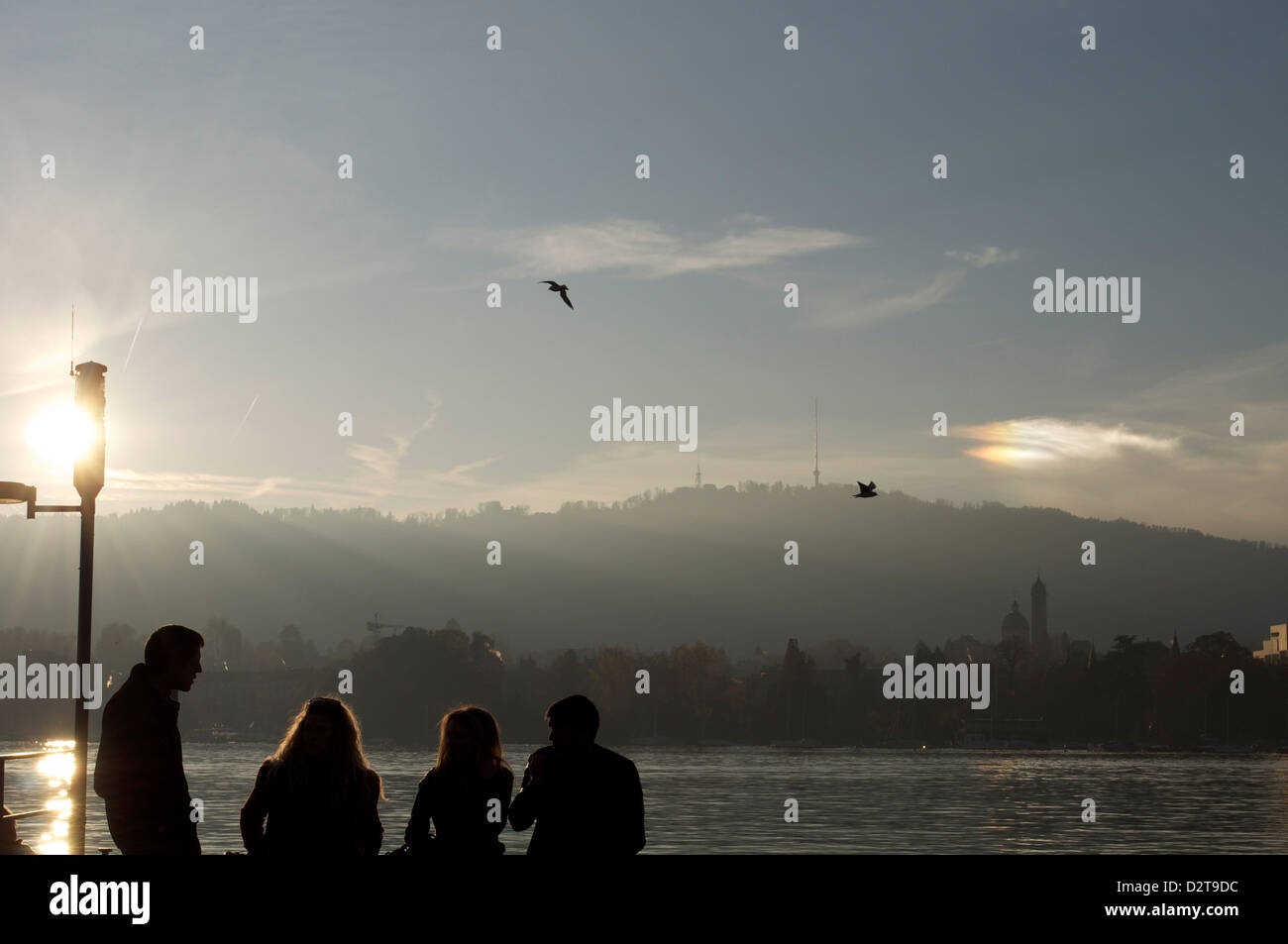 Sunset along the lake of Zurich with people in silhouette Stock Photo ...