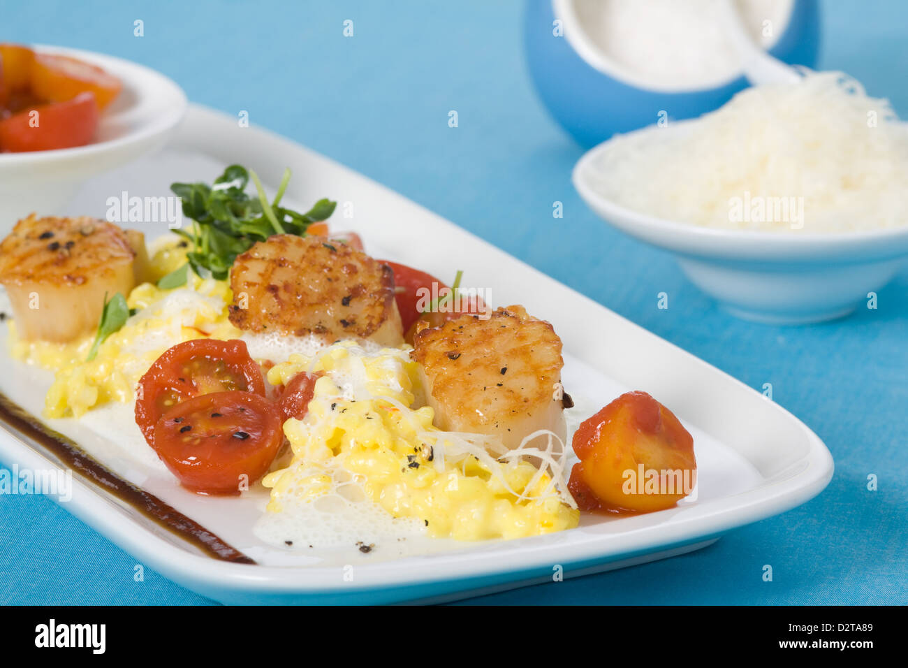 Saffron risotto with grilled scallops and cherry tomatoes sauce Stock ...