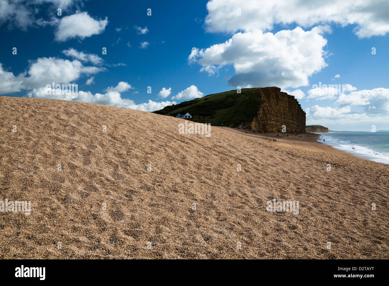 The steep shingle beach of West Bay with the impressive East Cliff ...
