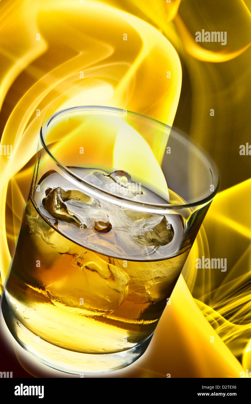 Glass of whisky with ice and fire in the background Stock Photo - Alamy