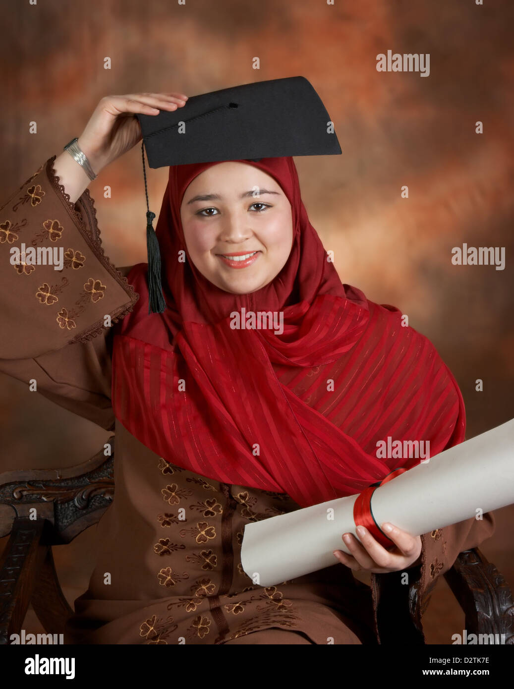 Happy islamic student holding her graduation cap above her traditional ...