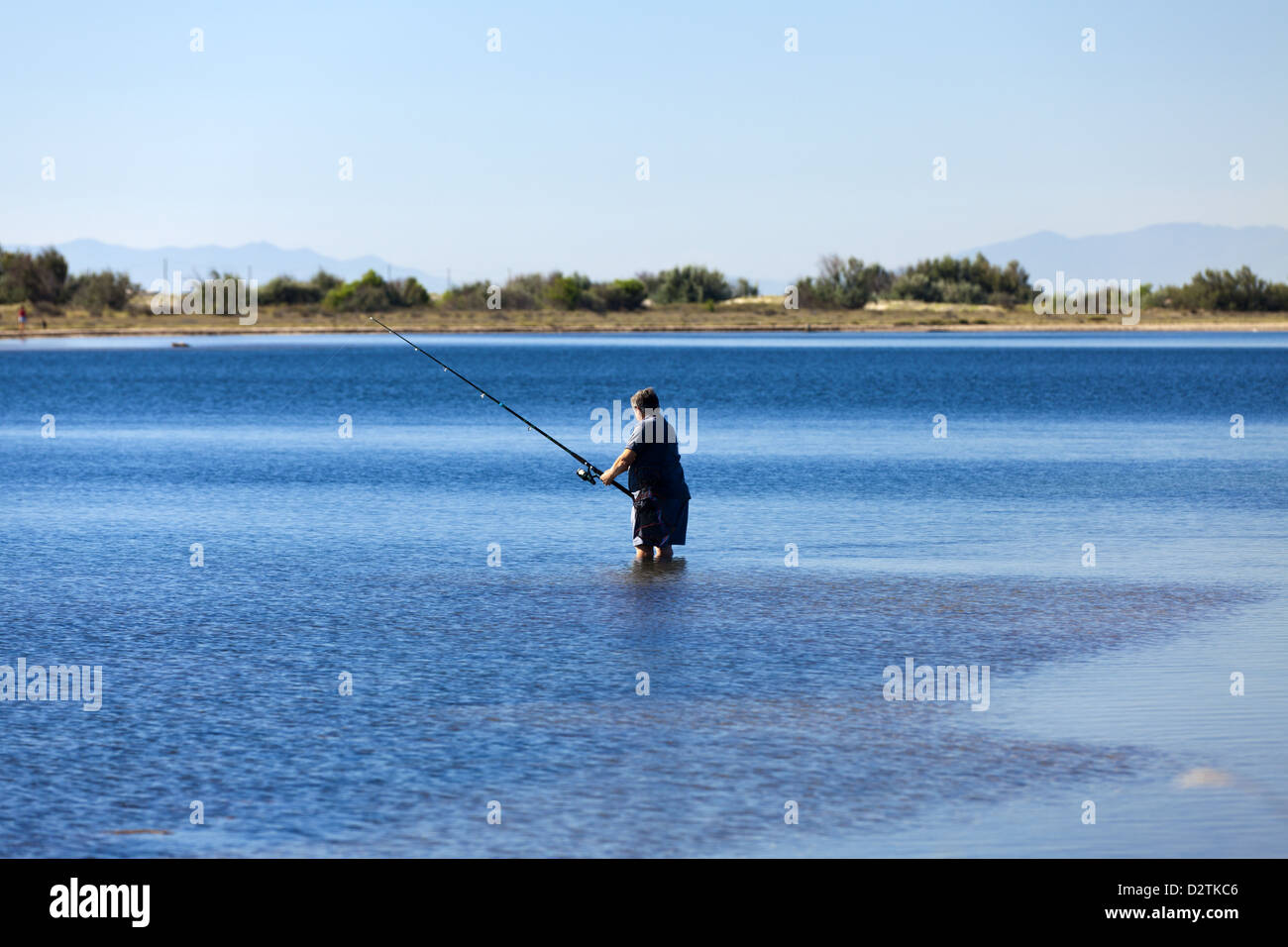 An angler stands in the bay in the resort of Gruissan on the French ...
