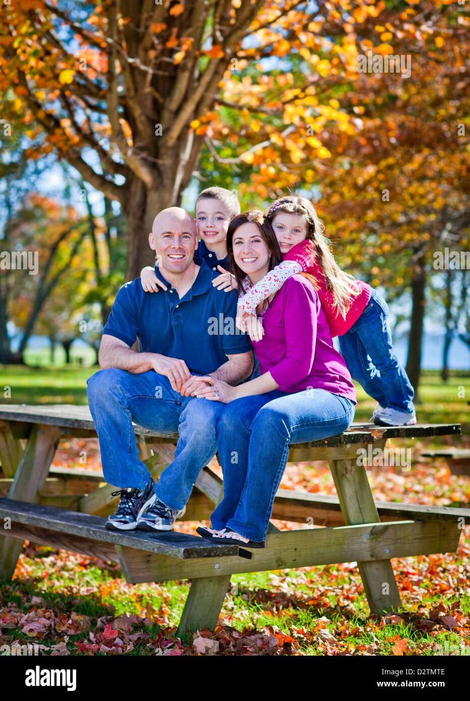 Family sitting on bench during the fall Stock Photo - Alamy
