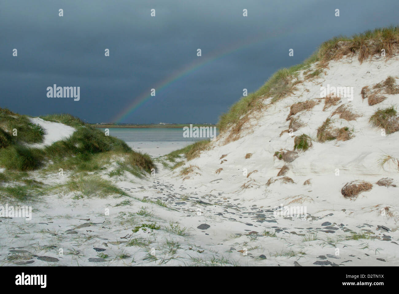 A rainbow seen through the sand dunes at Cata Sand on the island of ...
