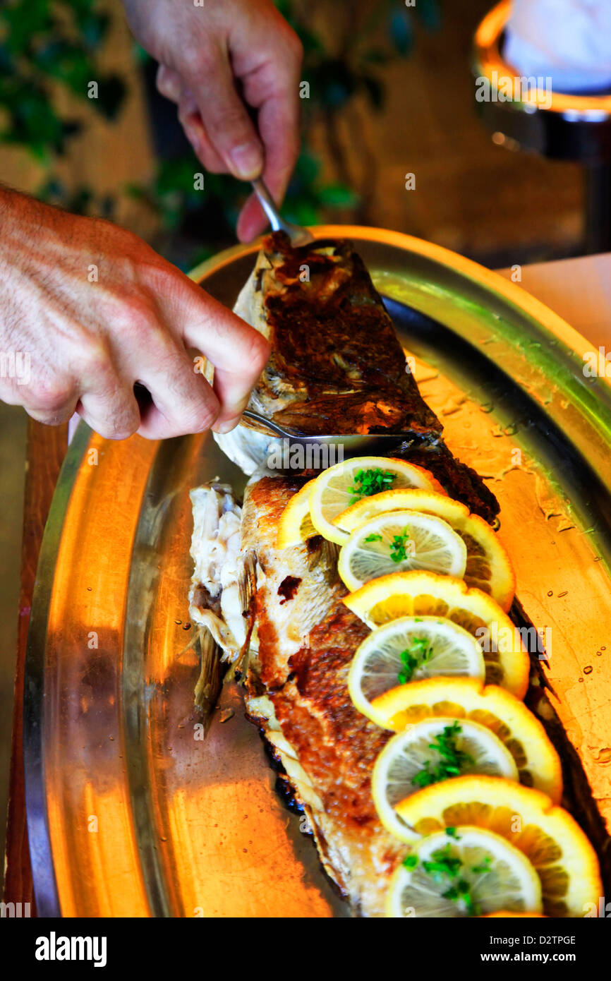 The waiter dresss a fish with a lemon at restaurant Stock Photo - Alamy