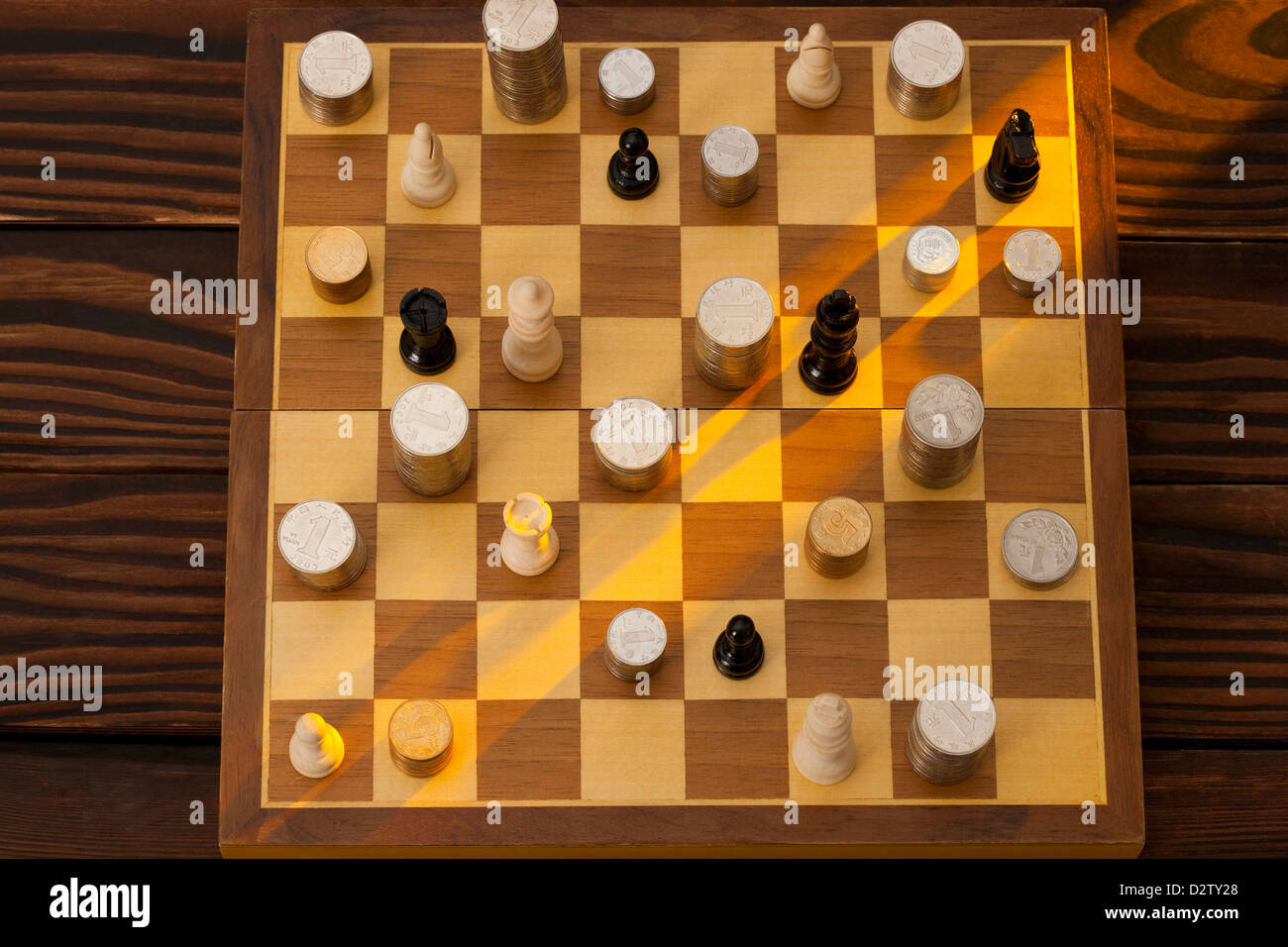 Coins and chess pieces on chess board Stock Photo - Alamy