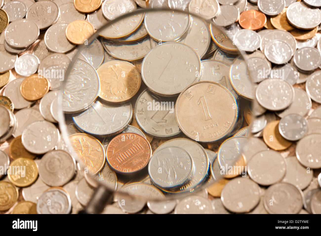 Coins and magnifying glass Stock Photo - Alamy