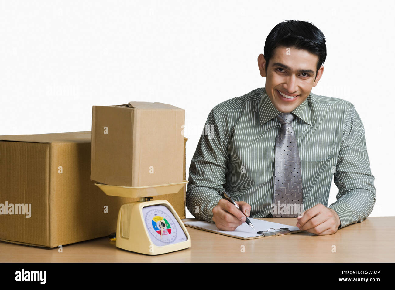 Portrait of a man weighing cardboard boxes and recording data Stock ...