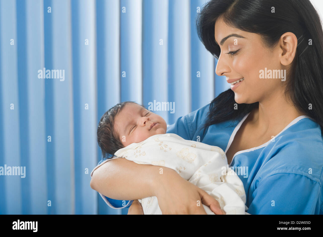 Woman carrying her baby and smiling Stock Photo - Alamy