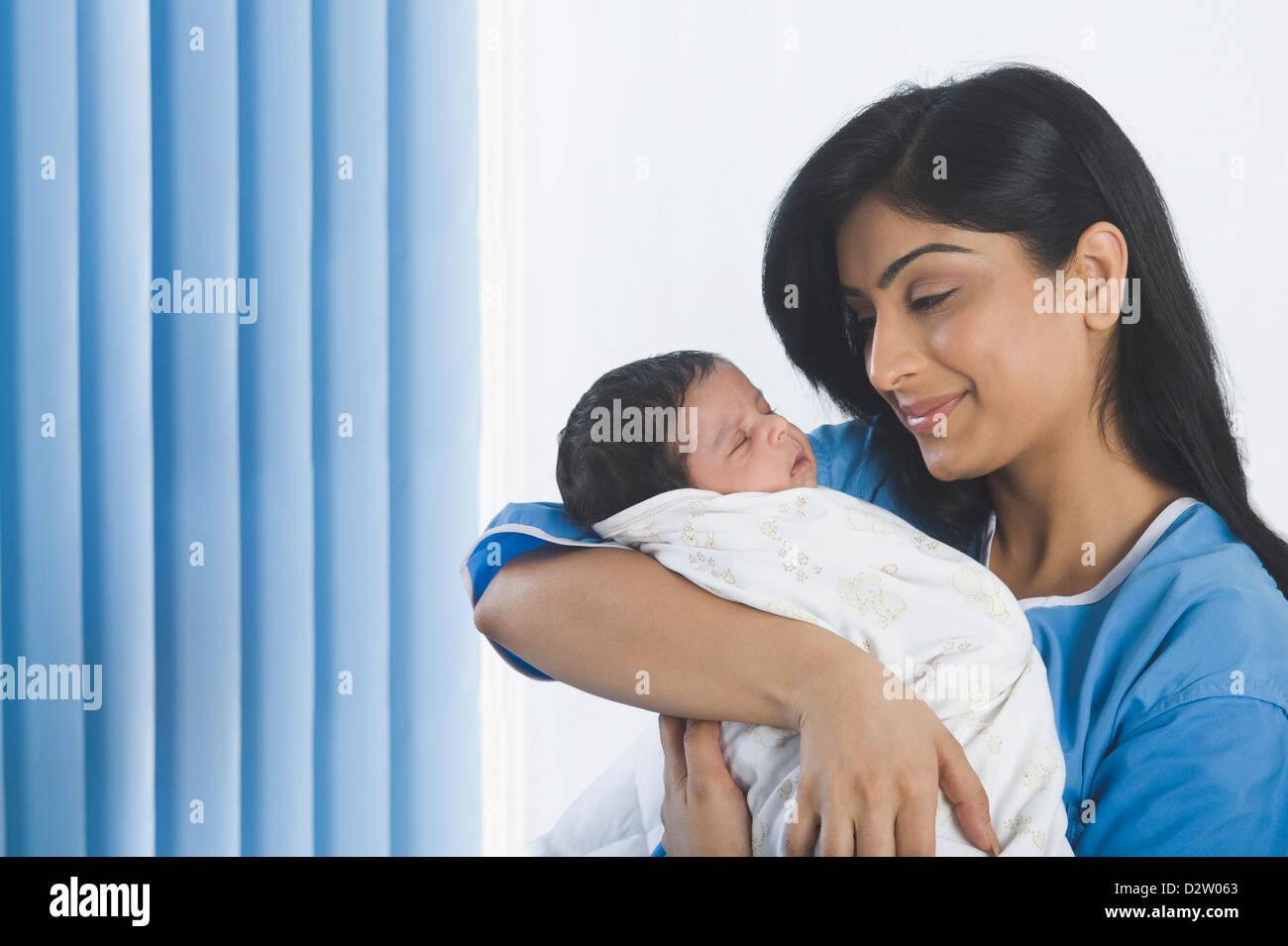 Woman carrying her baby and smiling Stock Photo - Alamy