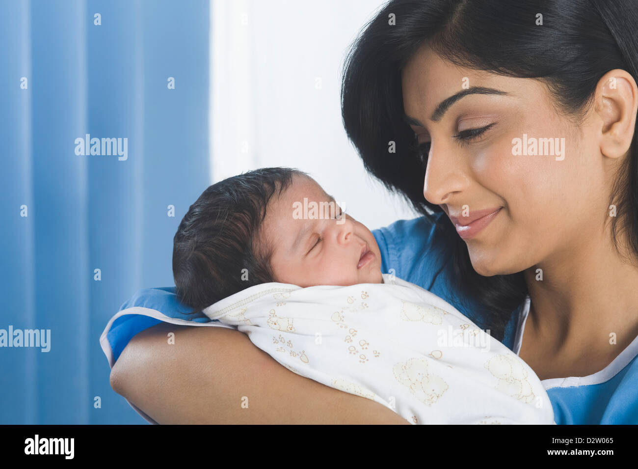 Woman carrying her baby Stock Photo - Alamy