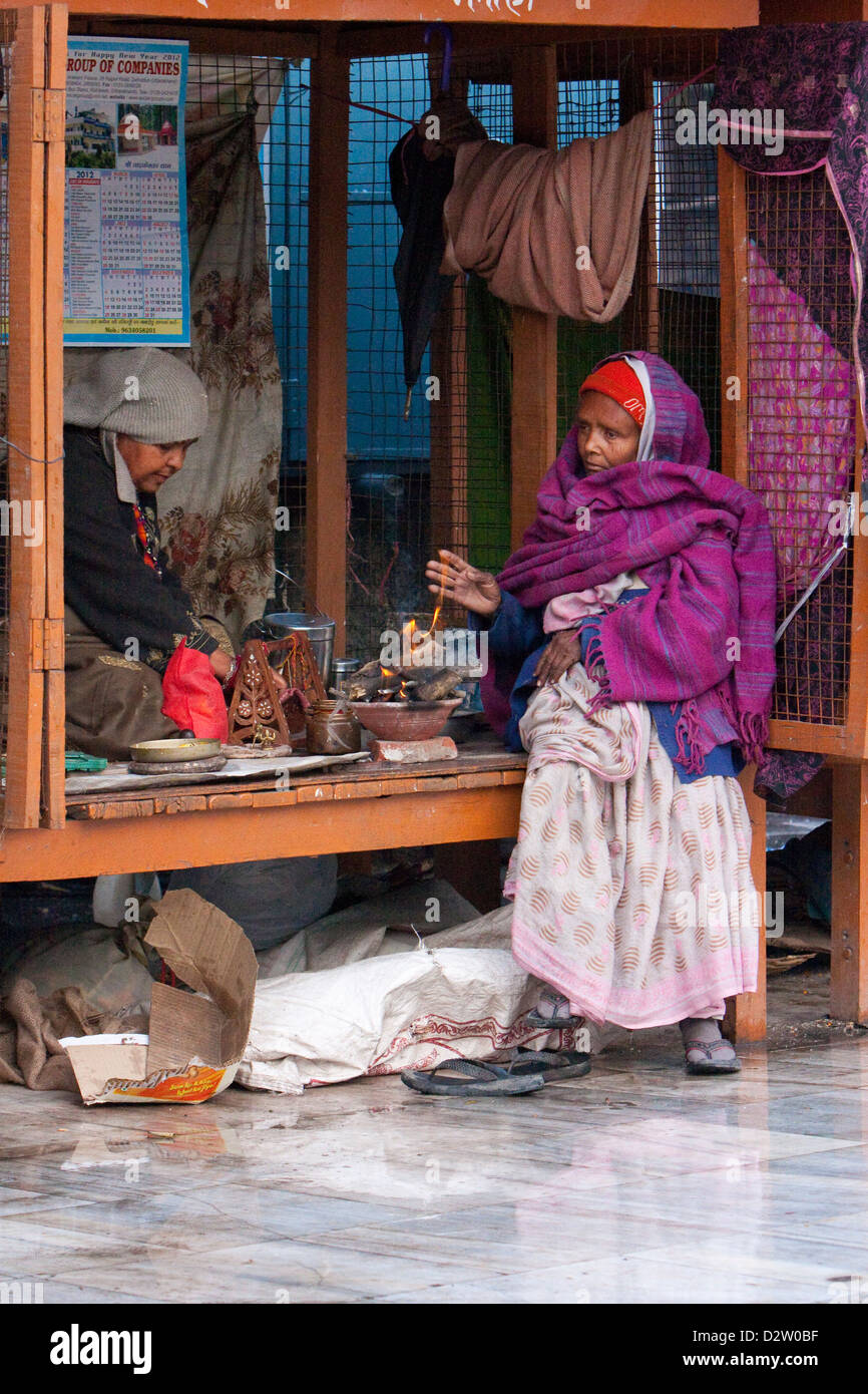 India, Rishikesh. Woman Warming her Hands in the Morning Cold Stock ...