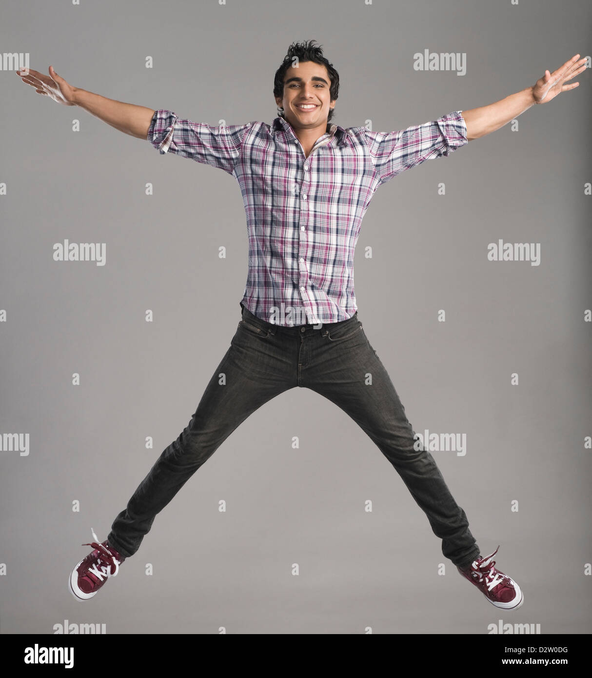 Portrait of a man jumping with his arm outstretched Stock Photo - Alamy