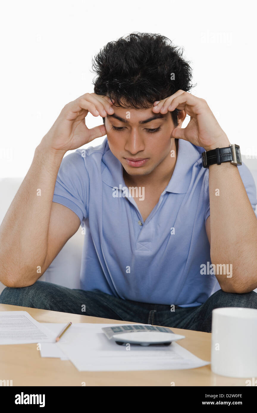 Man doing paperwork at home and thinking Stock Photo - Alamy