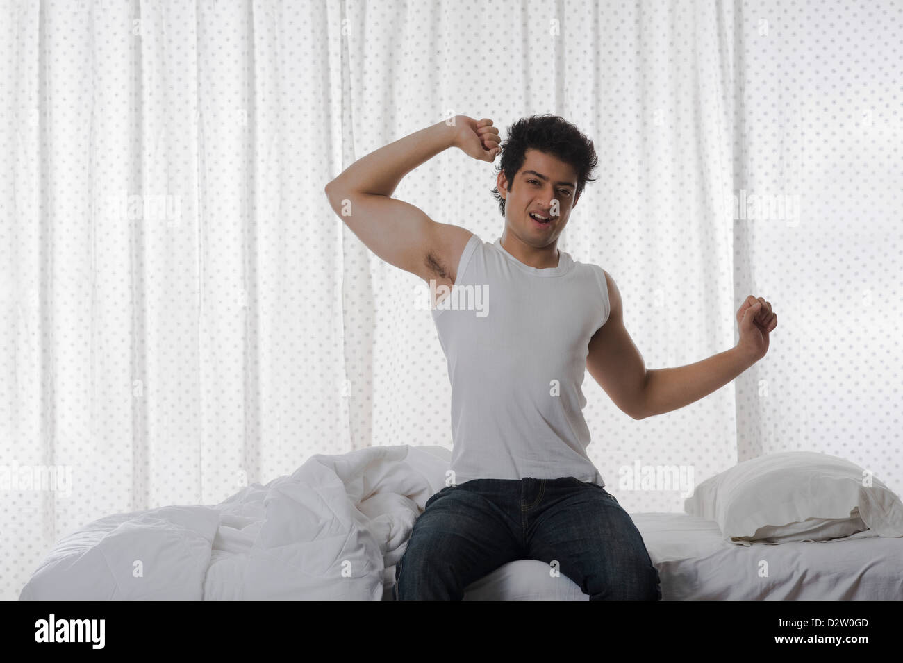 Man yawning and stretching on the bed Stock Photo - Alamy