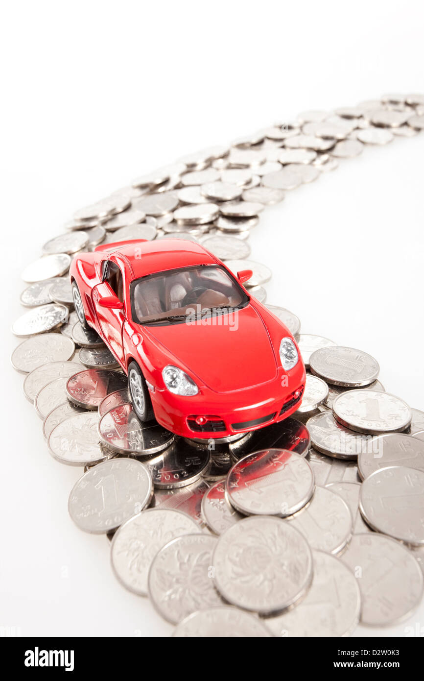 Toy car running on coins Stock Photo - Alamy