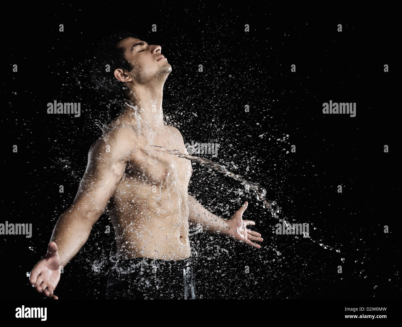 Bare chested man splashed with water Stock Photo - Alamy