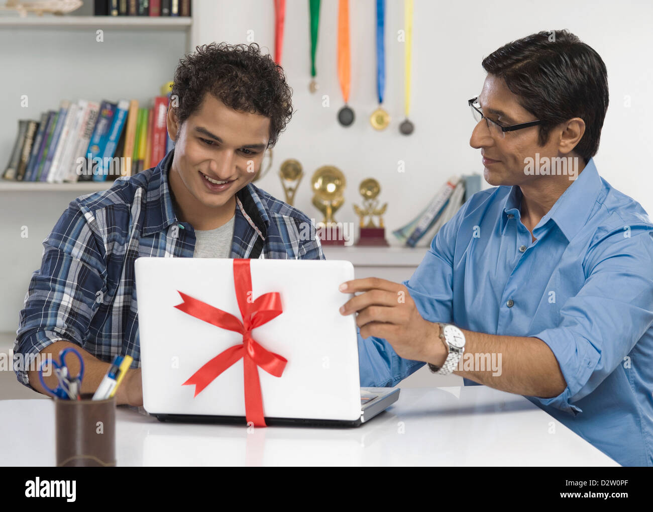 Man gifting a laptop to his son Stock Photo - Alamy