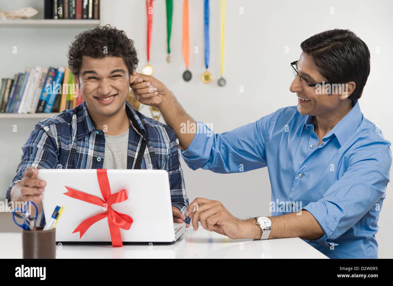 Man pulling ear of his son Stock Photo - Alamy