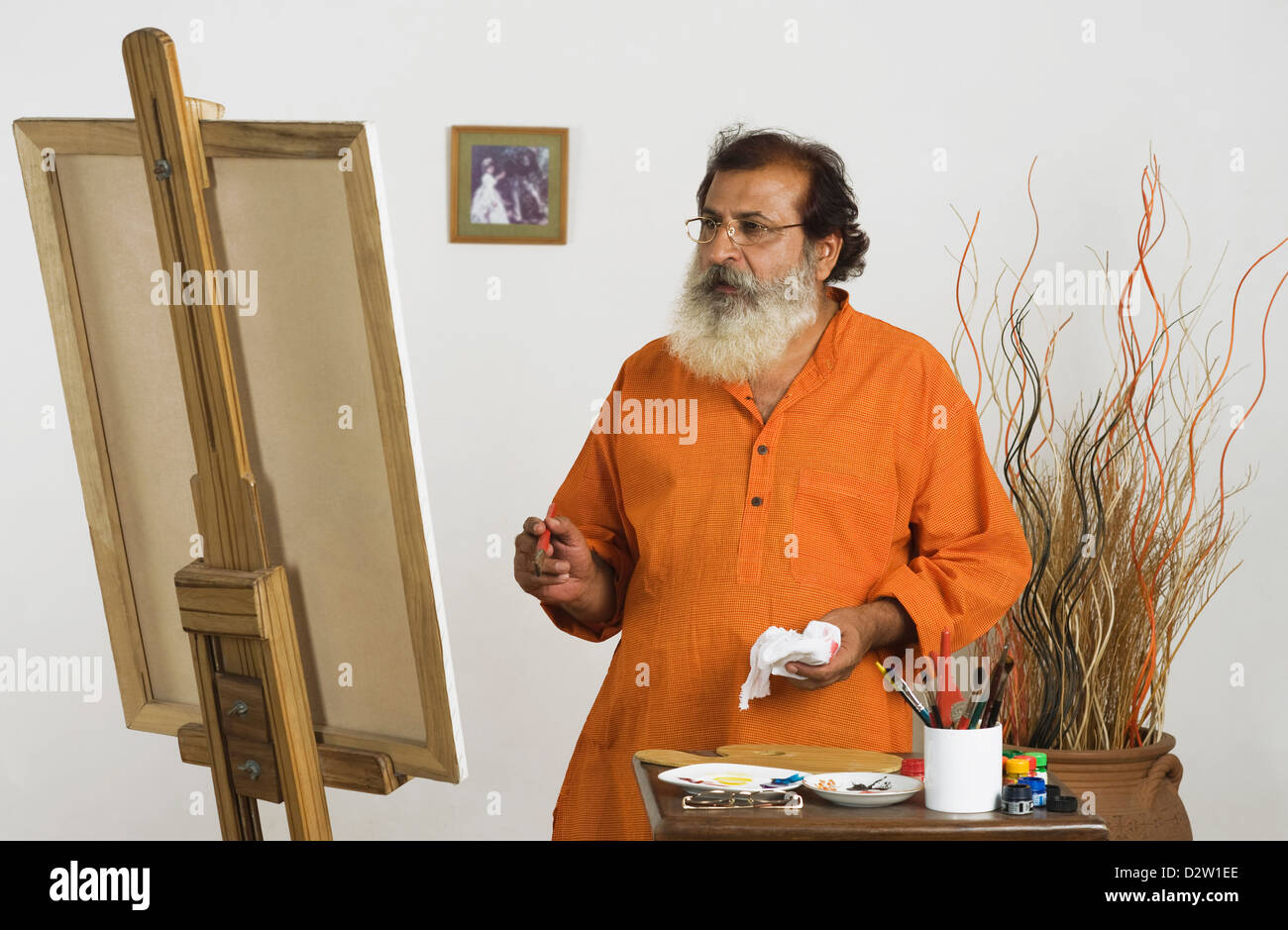 Artist looking at painting Stock Photo - Alamy