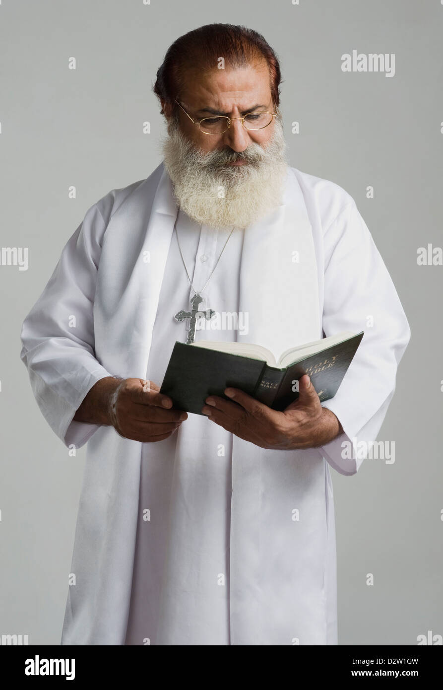 Priest reading a holy book Stock Photo - Alamy