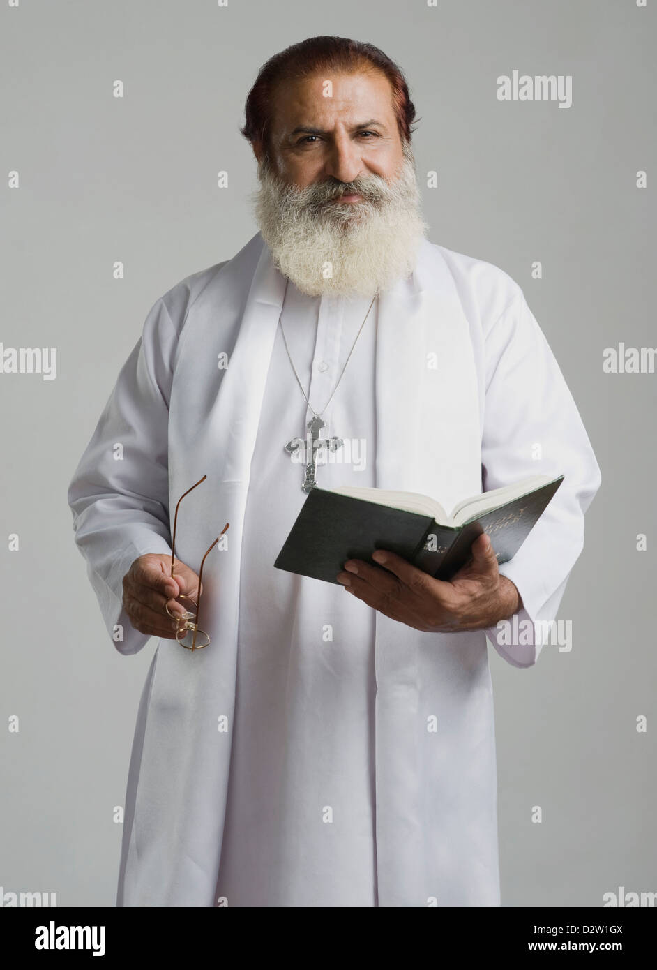 Priest holding a holy book Stock Photo - Alamy