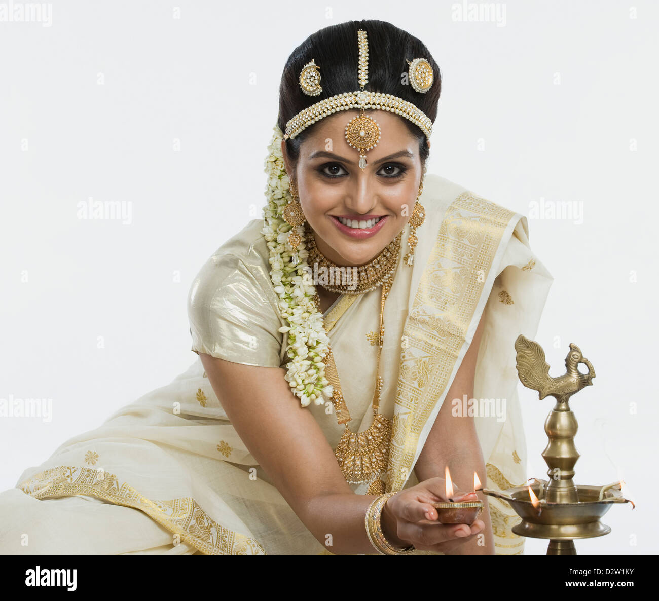 Indian woman in traditional clothing lighting an oil lamp Stock Photo ...