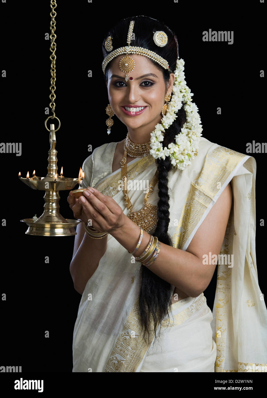Traditional indian woman lighting diya hi-res stock photography and ...