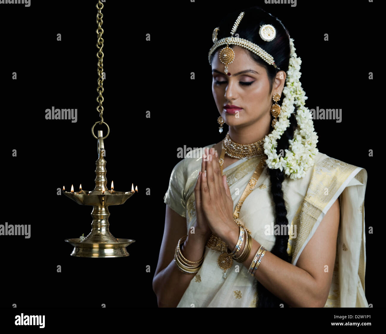 Indian woman in traditional clothing praying at Durga puja festival ...