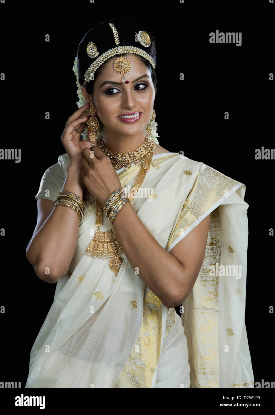 Indian woman in traditional clothing adjusting her earrings Stock Photo ...