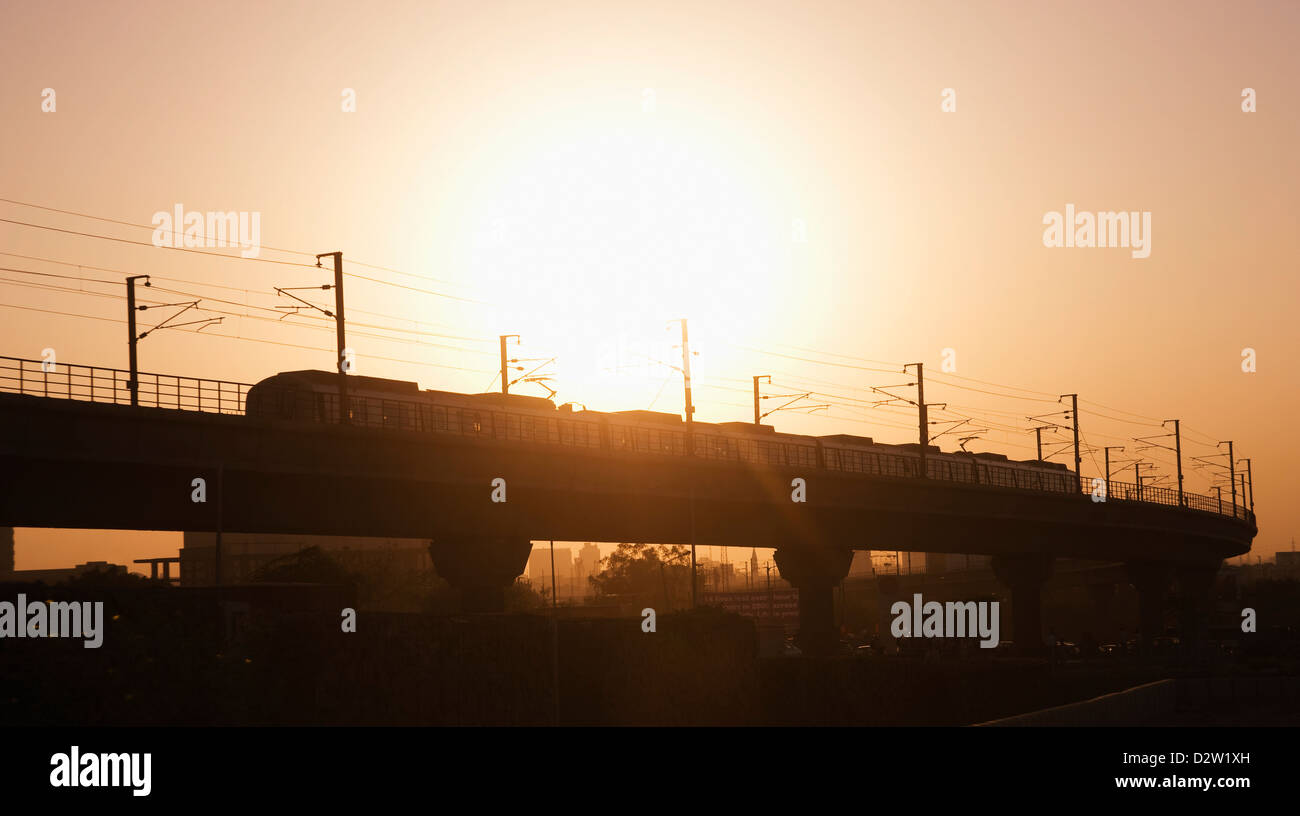 Metro train on elevated tracks at sunset, Delhi, India Stock Photo - Alamy