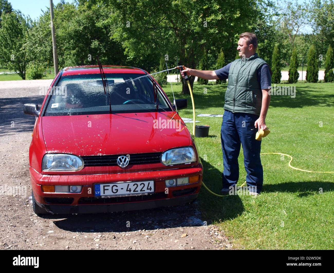 Young man washing red car outdoor on green grass Stock Photo - Alamy