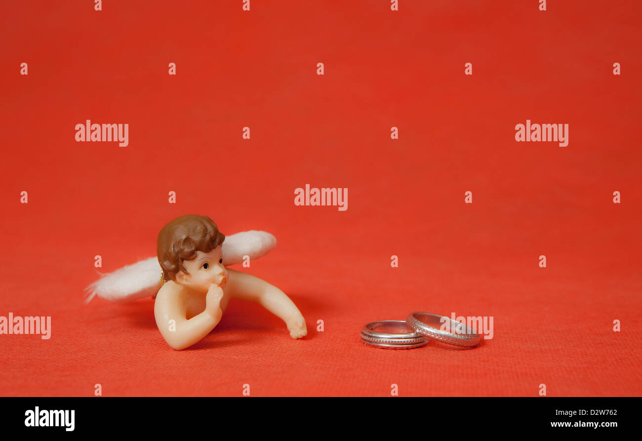 Two silver rings with angel in red background Stock Photo - Alamy