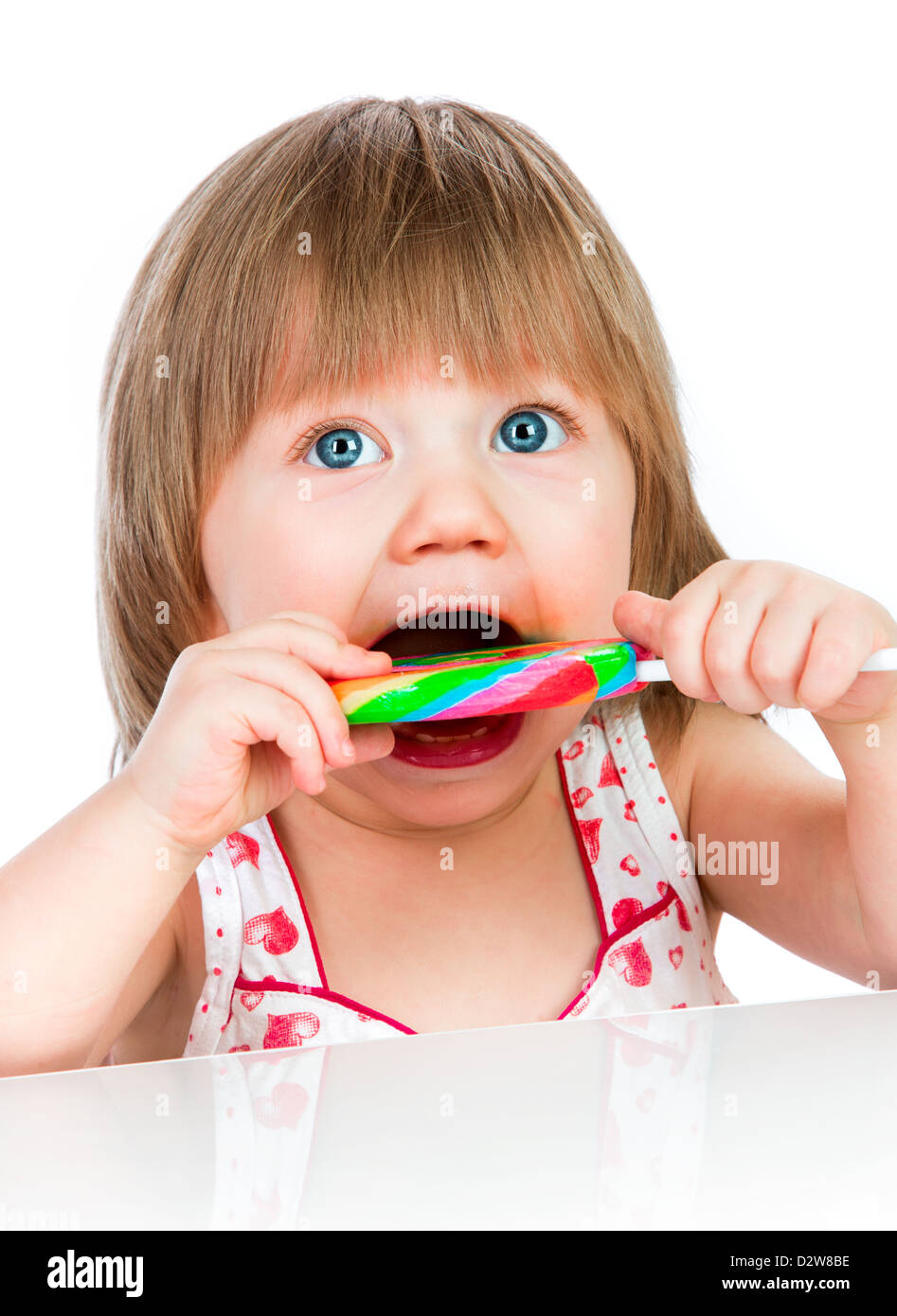 Baby girl eating a sticky lollipop on white background Stock Photo - Alamy