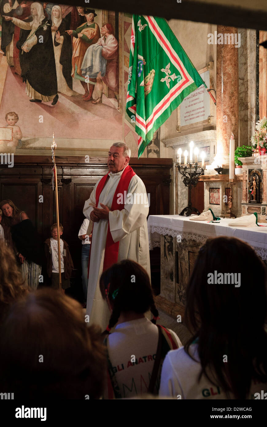 Priest of the Oca Contrade chapel of Saint Catherine talks to children ...