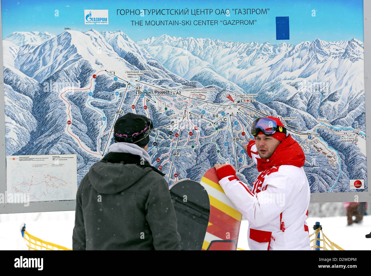 Two winter sport enthusiasts stand in front of a map of the slopes at ...