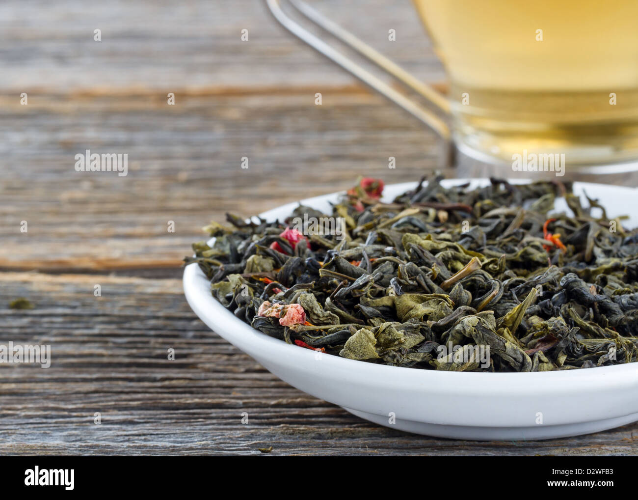 Green tea leaves on a plate, glass cup of tea in the background Stock ...