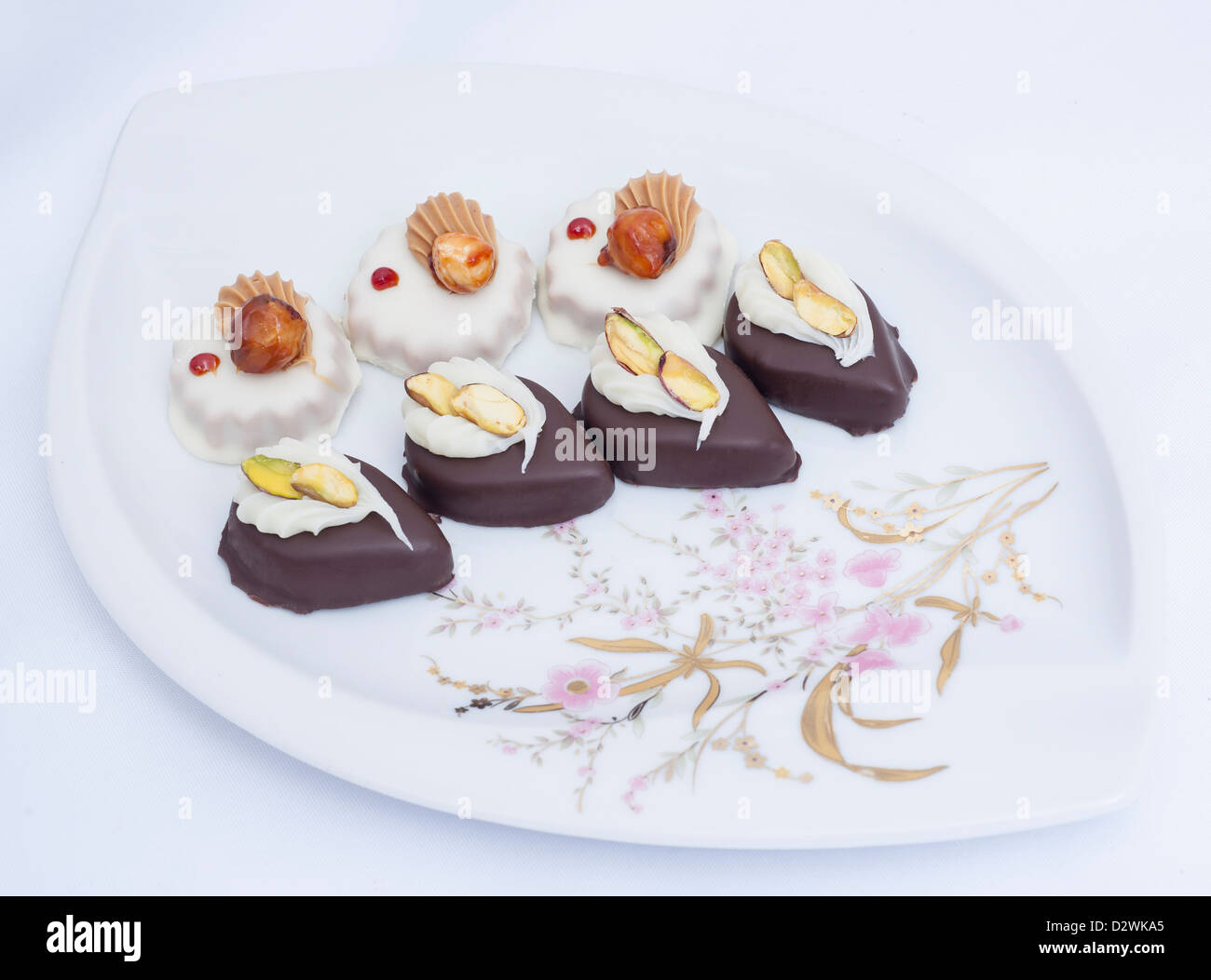 Selection of luxury oriental petit fours isolated on a white plate ...