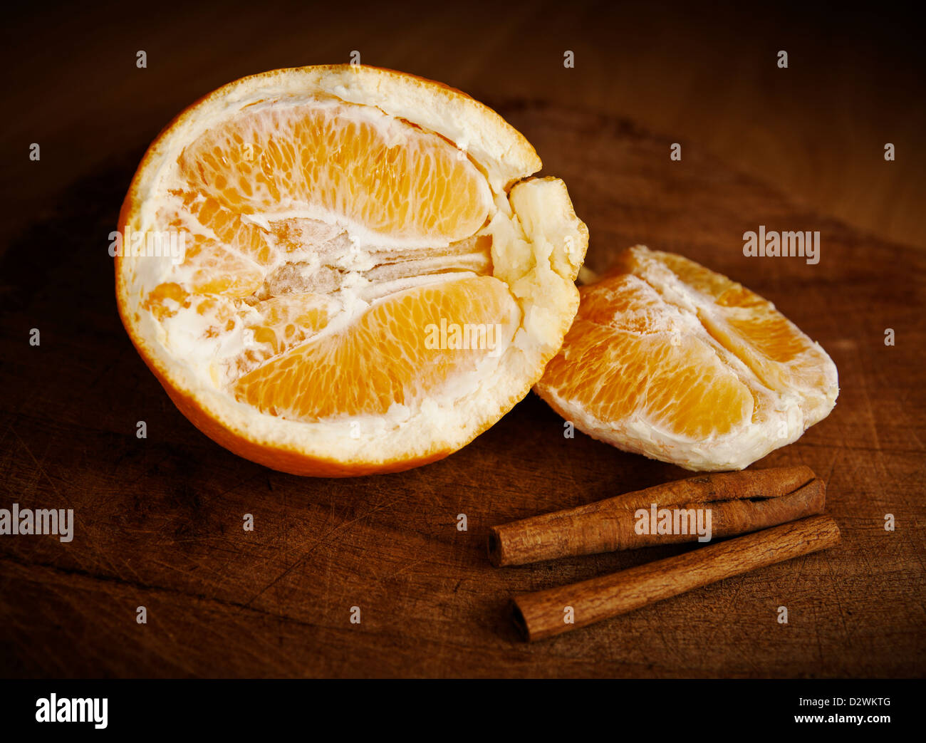 A split orange and a couple of cinnamon sticks Stock Photo - Alamy